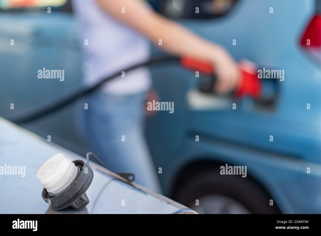 Caucasian woman refueling a car at a self-service gas station Stock ...