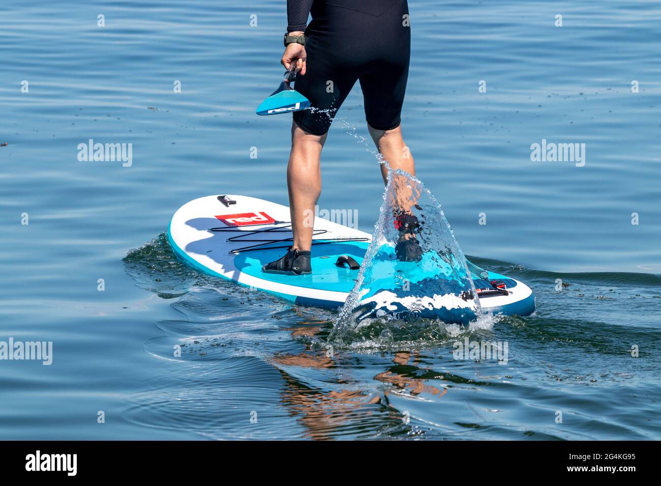 Close up of a mans legs standing on a Paddleboard using a oar Stock ...