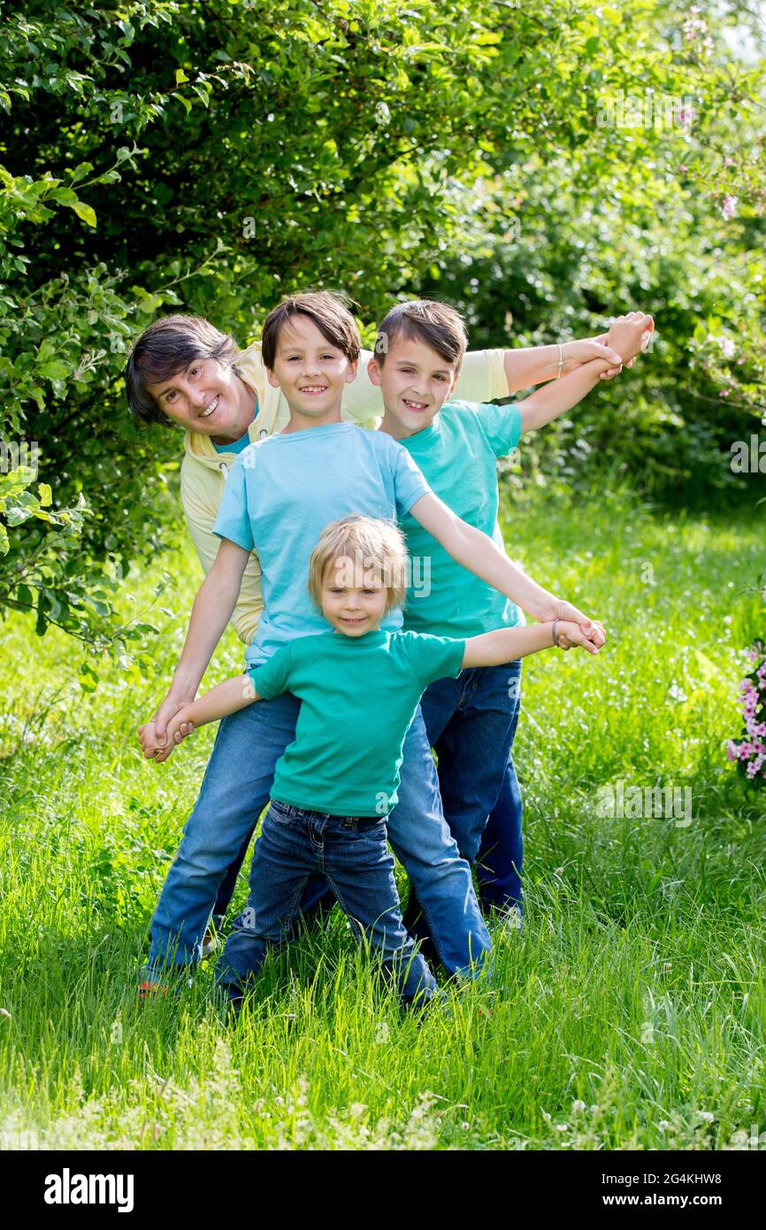 Grandmother and grandchildren, playing together in the park, springtime ...