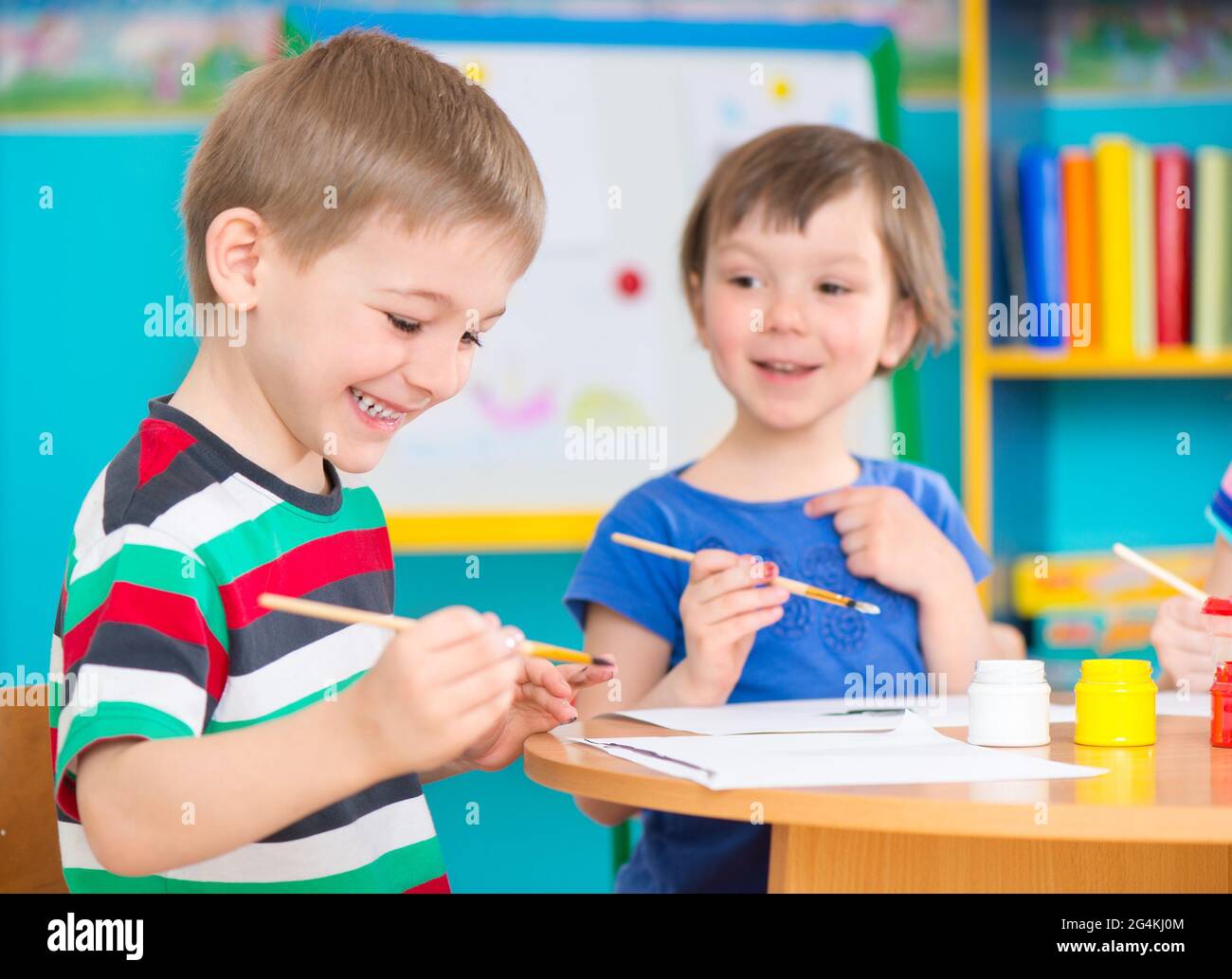 Cute little preschool children drawing with colorful paints at ...