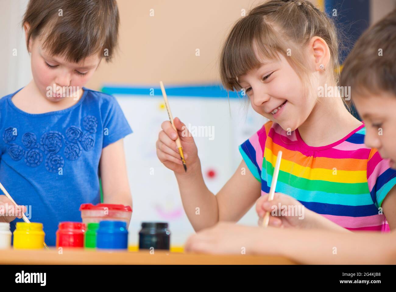 Cute little preschool children drawing with colorful paints at ...