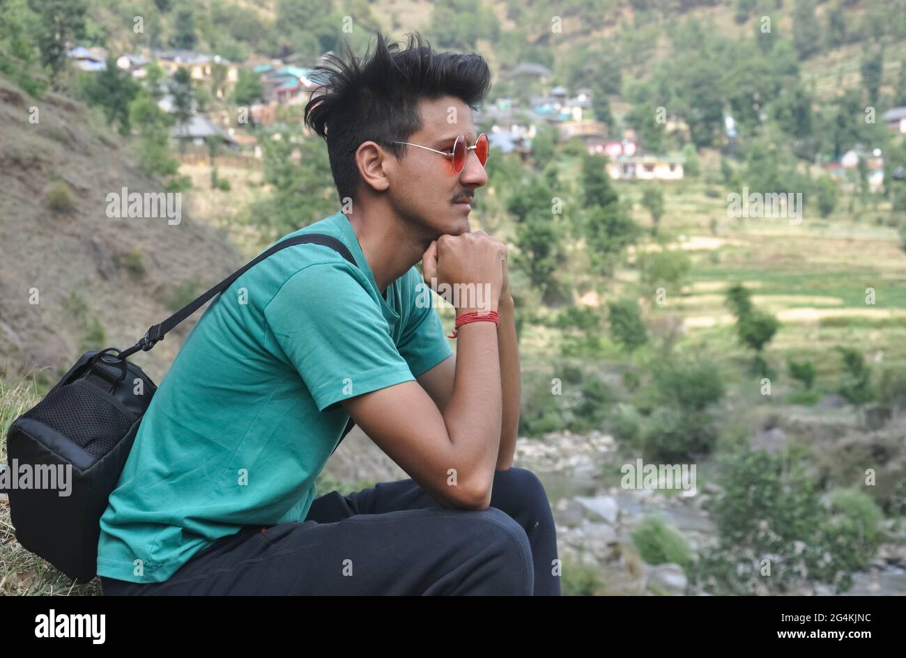 Side view of a good looking guy wearing sunglass and carrying camera ...