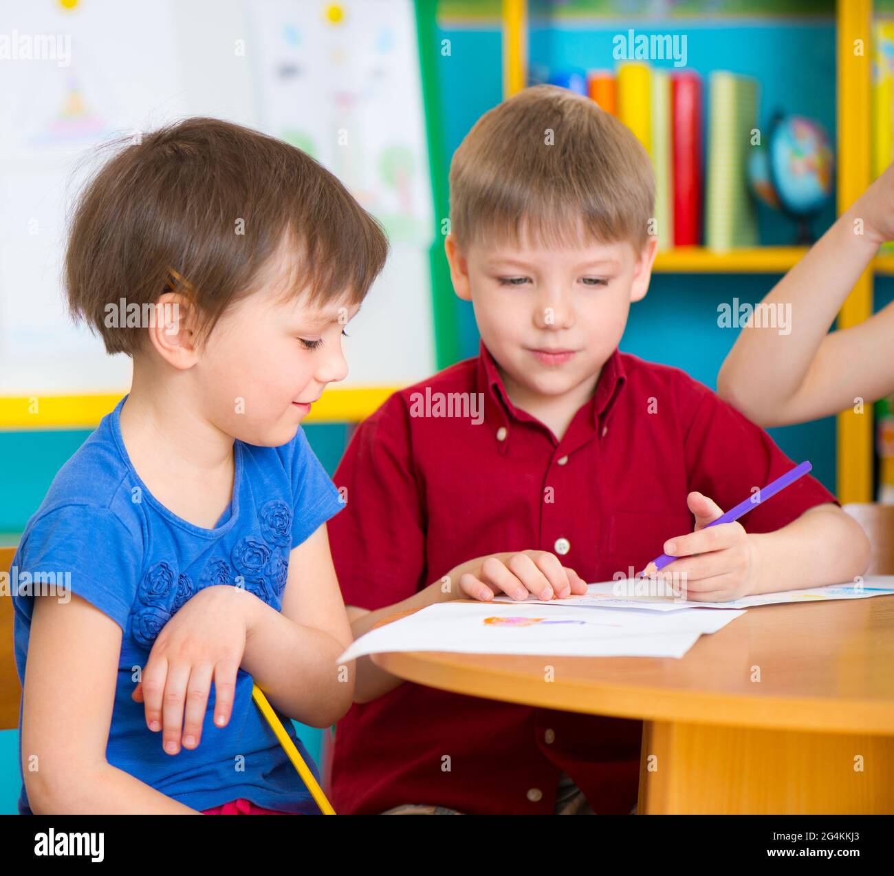 Two cute children drawing with colorful pencils at kindergarten Stock ...