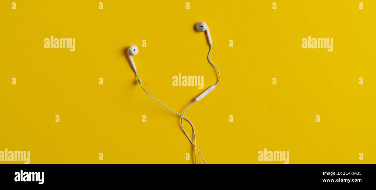 view from above of the white wired simple earbuds earphones flat lay on ...