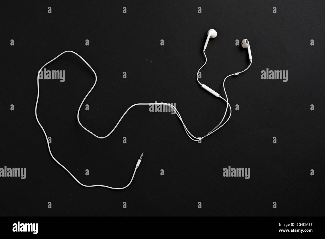 view from above of the white wired simple earbuds earphones flat lay on ...