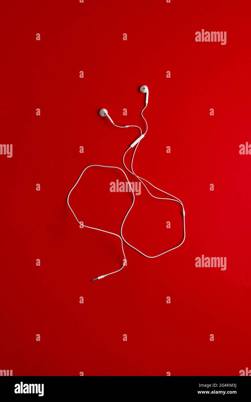view from above of the white wired simple earbuds earphones flat lay on ...