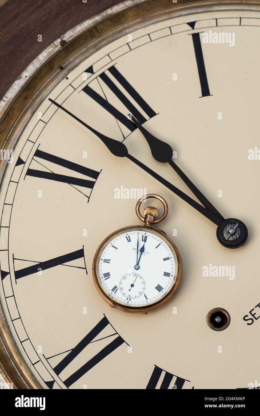 Two minutes to midnight. A pocket watch laid on a clock face Stock ...