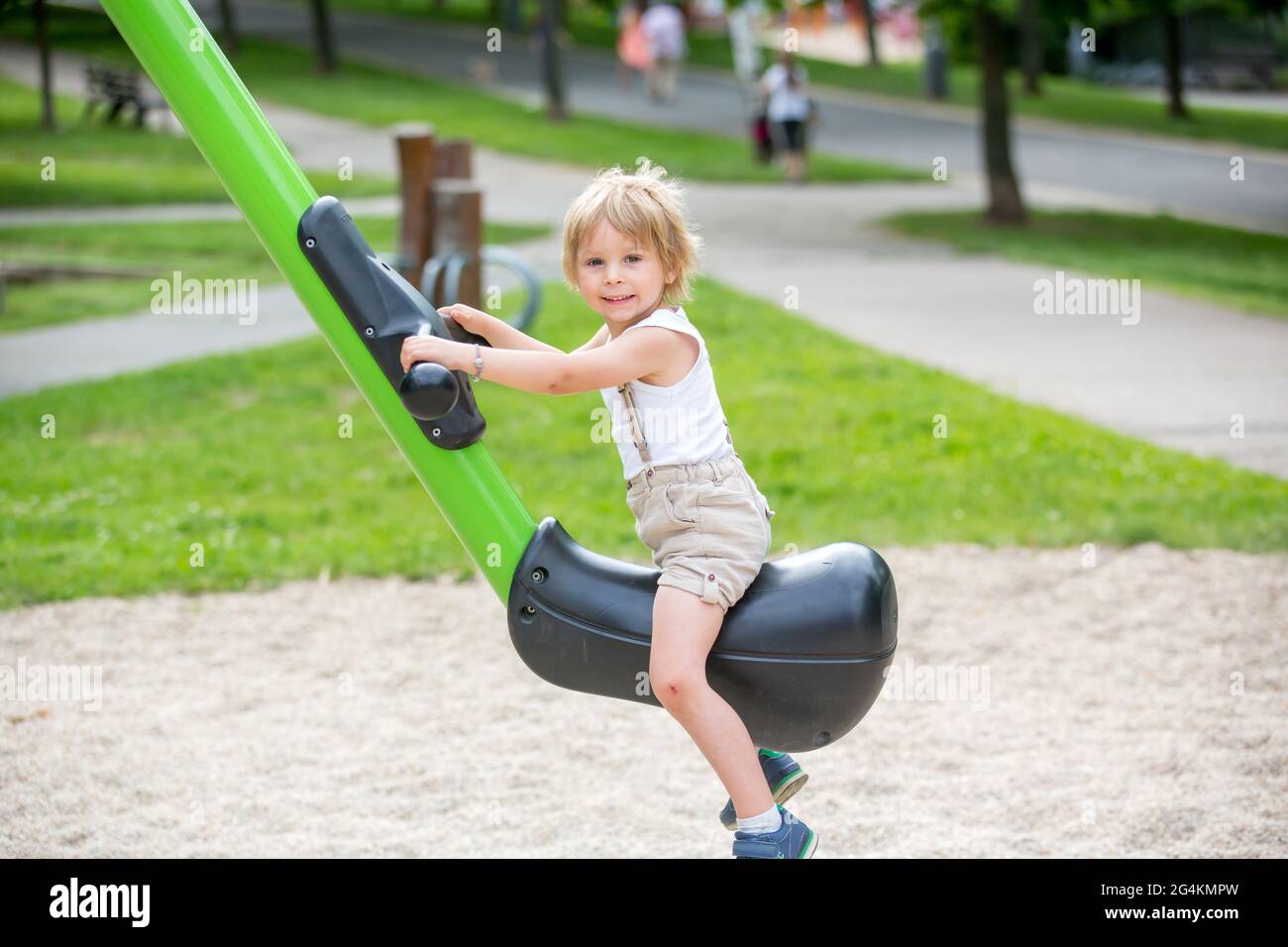 Little toddler child, blond cute boy, swinging in the park on the ...