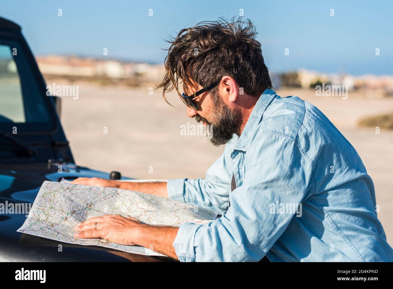 Adventure travel lifestyle - bearded adult man looking paper map to ...