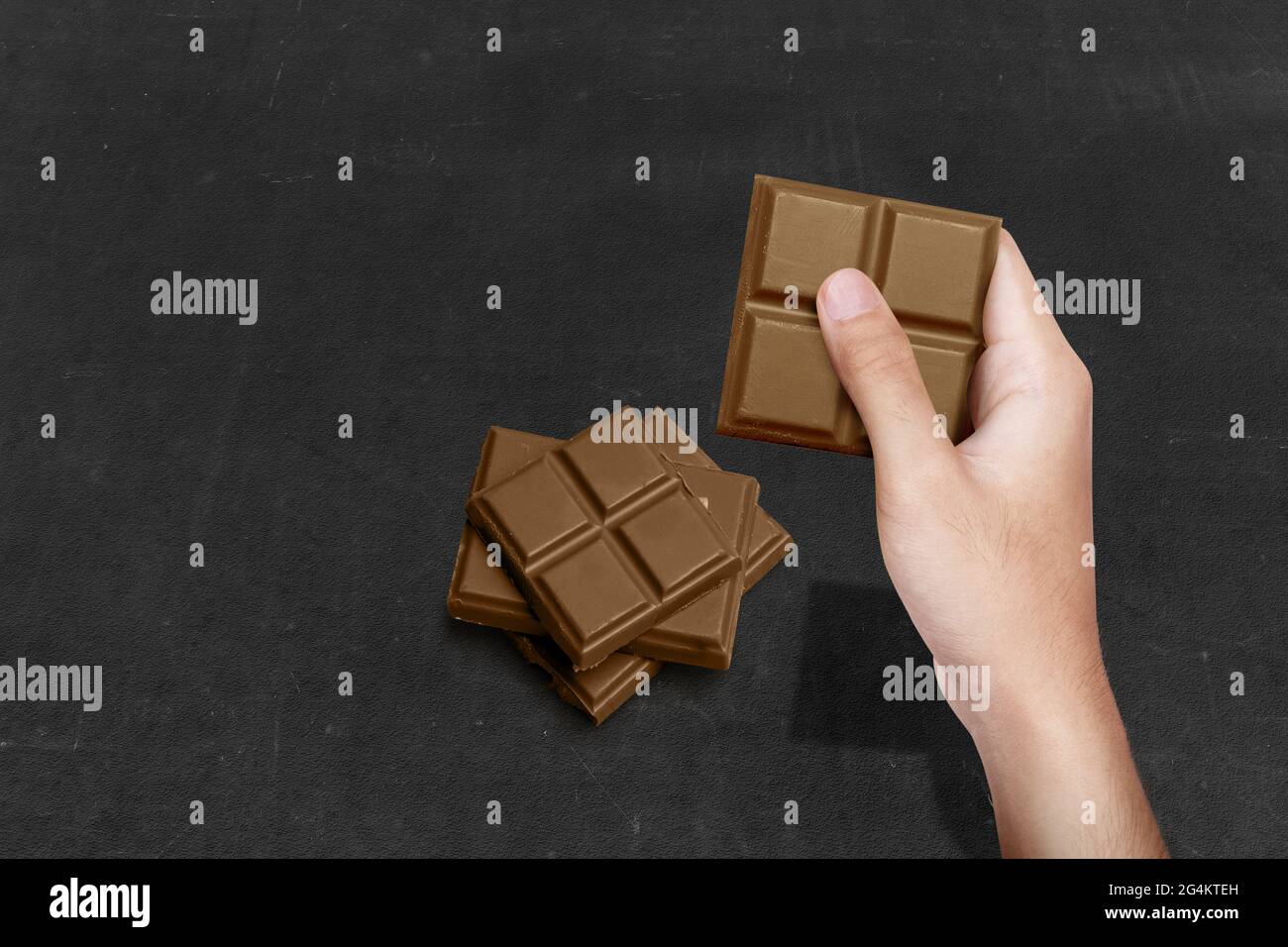 Human hand holding the chocolate bar with black background Stock Photo ...