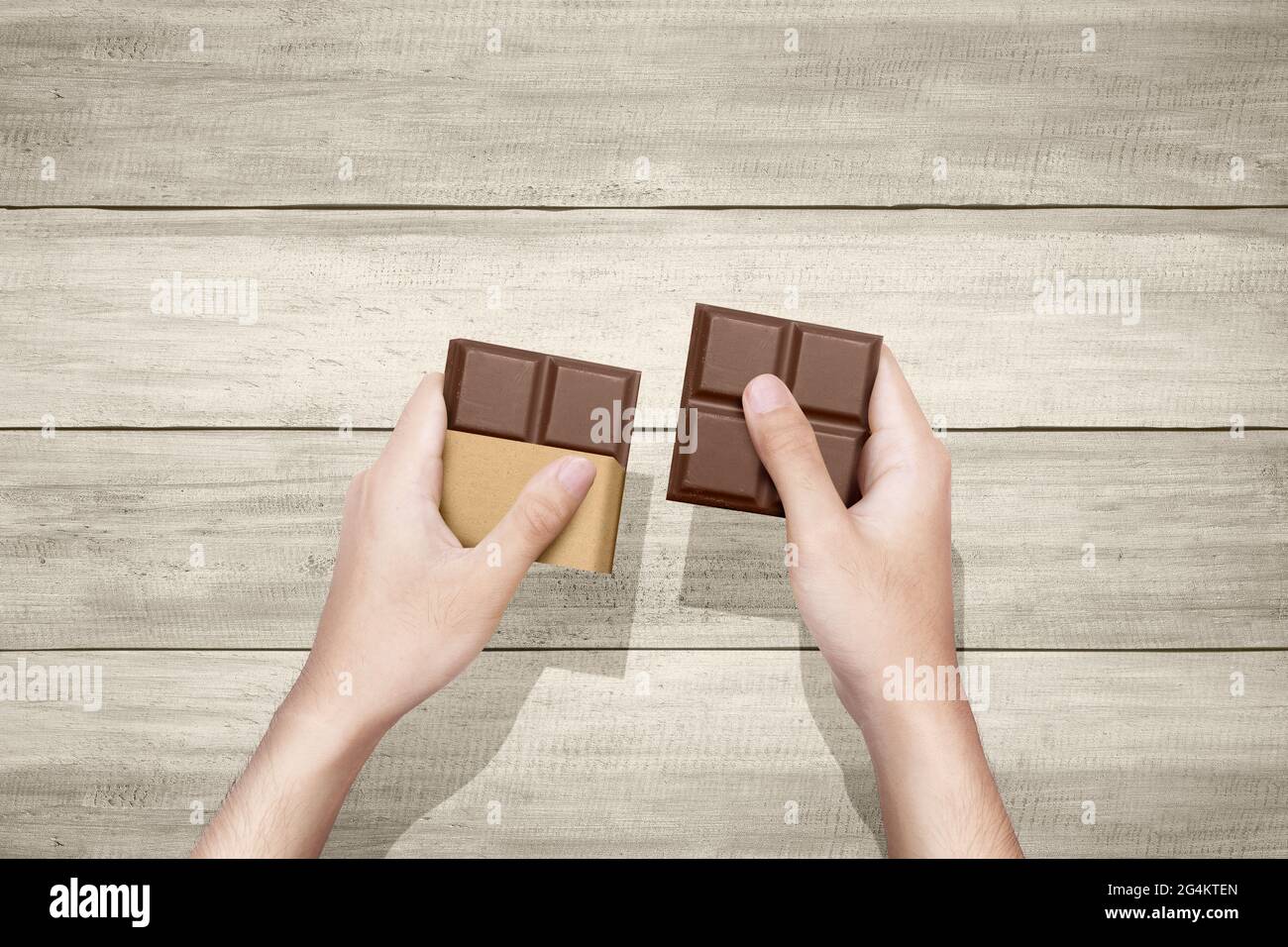 Human hand holding the chocolate bar with table background Stock Photo ...