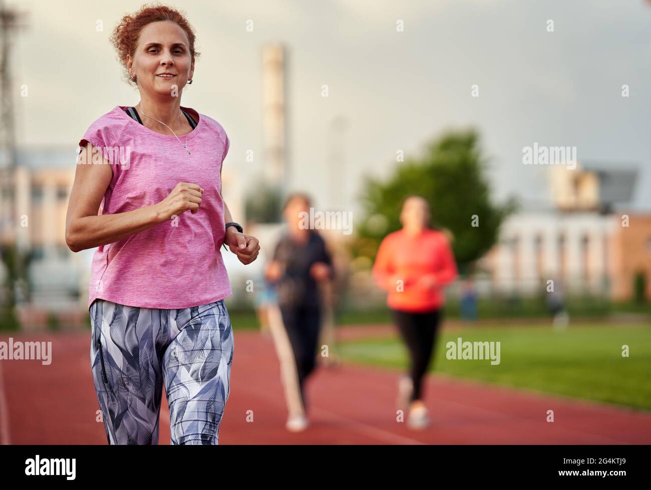 Woman running on a track in the city at sunset Stock Photo - Alamy