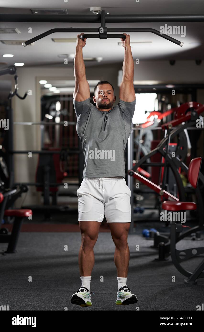Man doing pull-ups in the fitness gym at the bar Stock Photo - Alamy