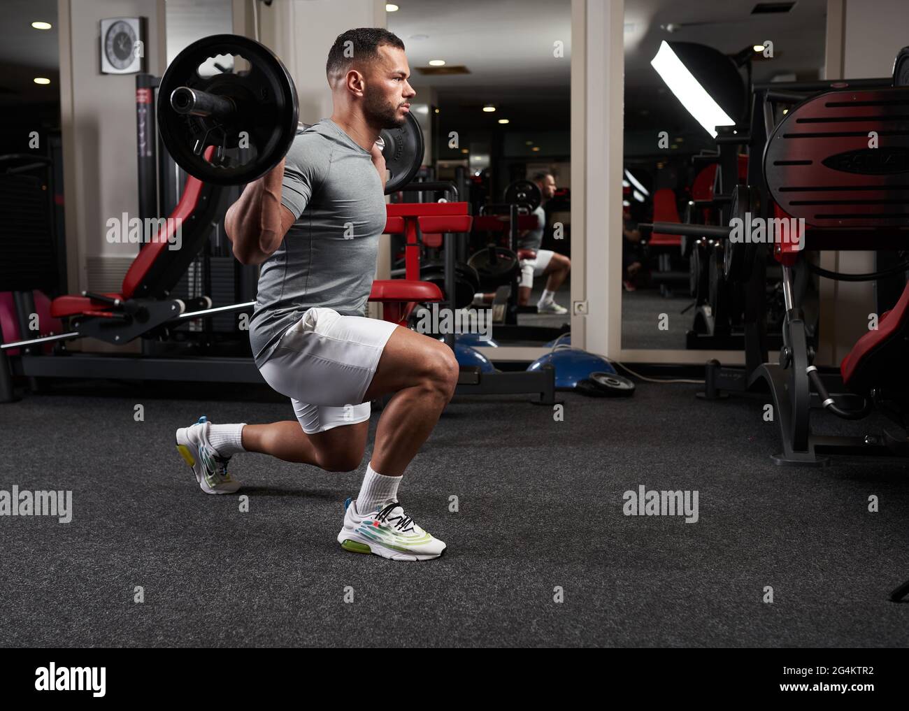 Fitness man doing lunges with barbell on his back in the gym Stock ...