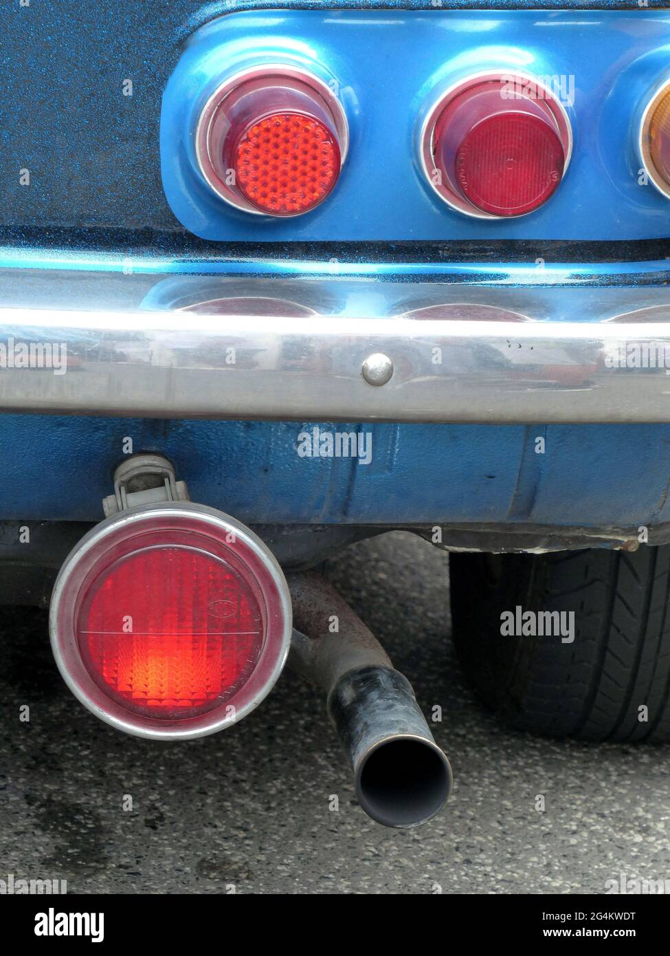 Vertical shot of the exhaust pipe and lights of a vintage blue car ...