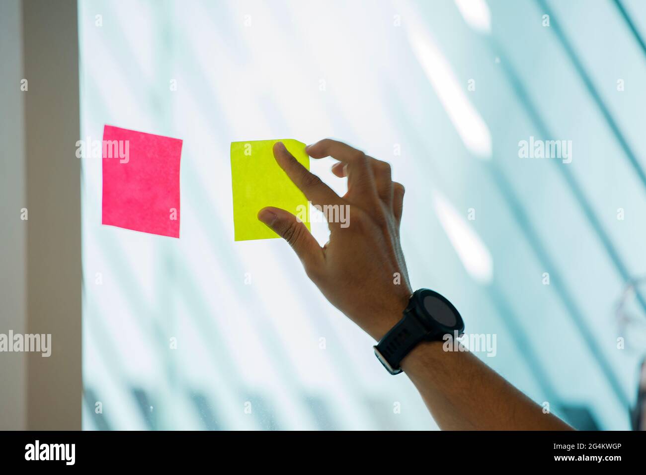 The businessperson put the empty sticky notes on the glass board in the ...