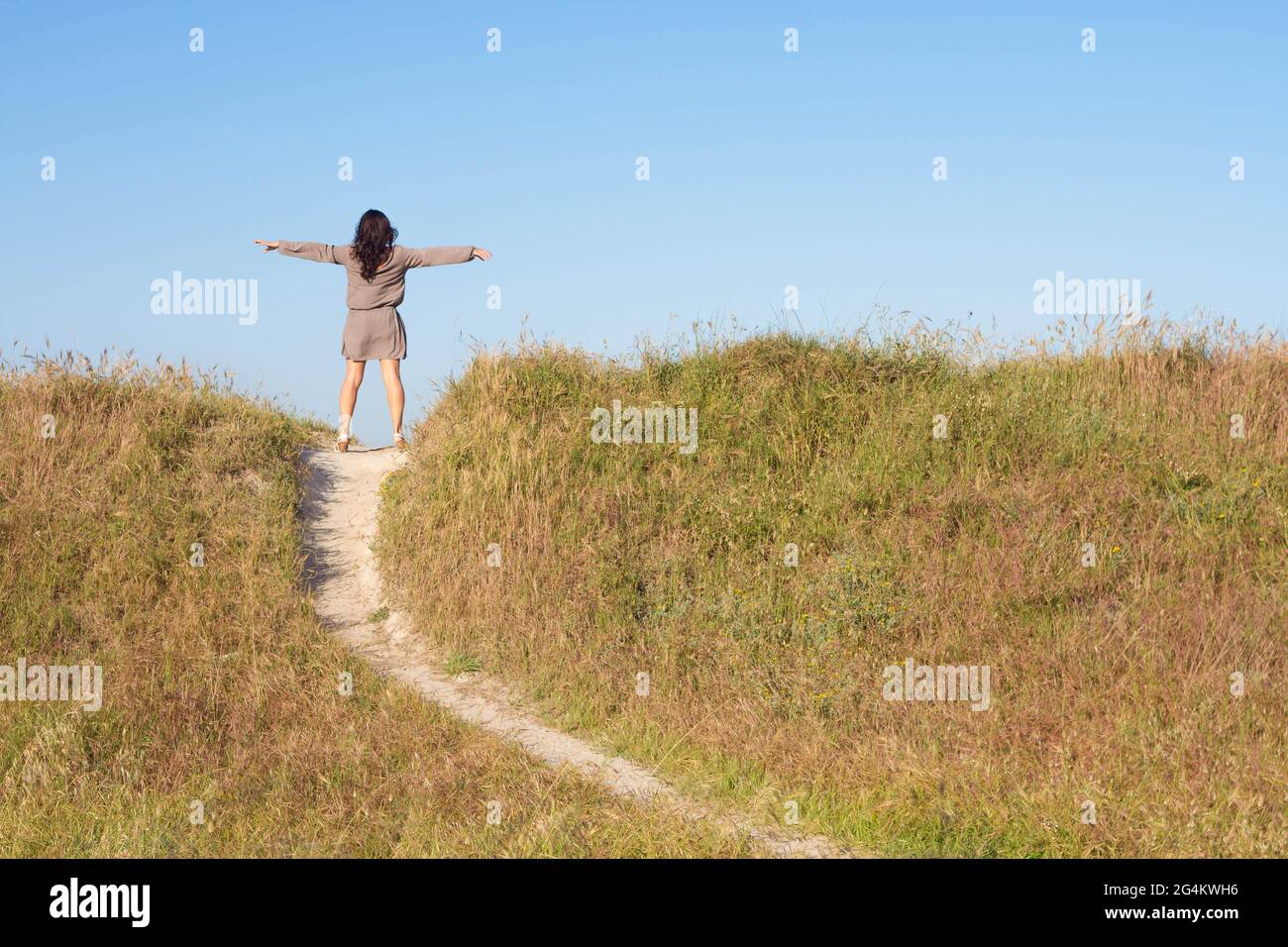 Woman jumping for success to the top of a hill Stock Photo - Alamy