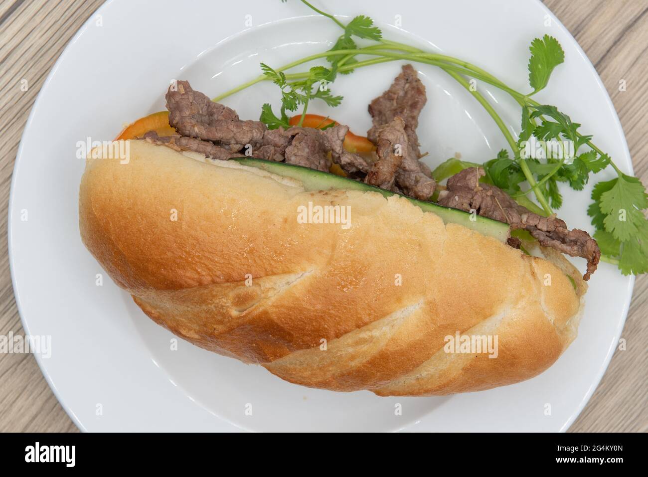 Overhead view of hearty plate holding a loaded lemongrass beef sandwich ...