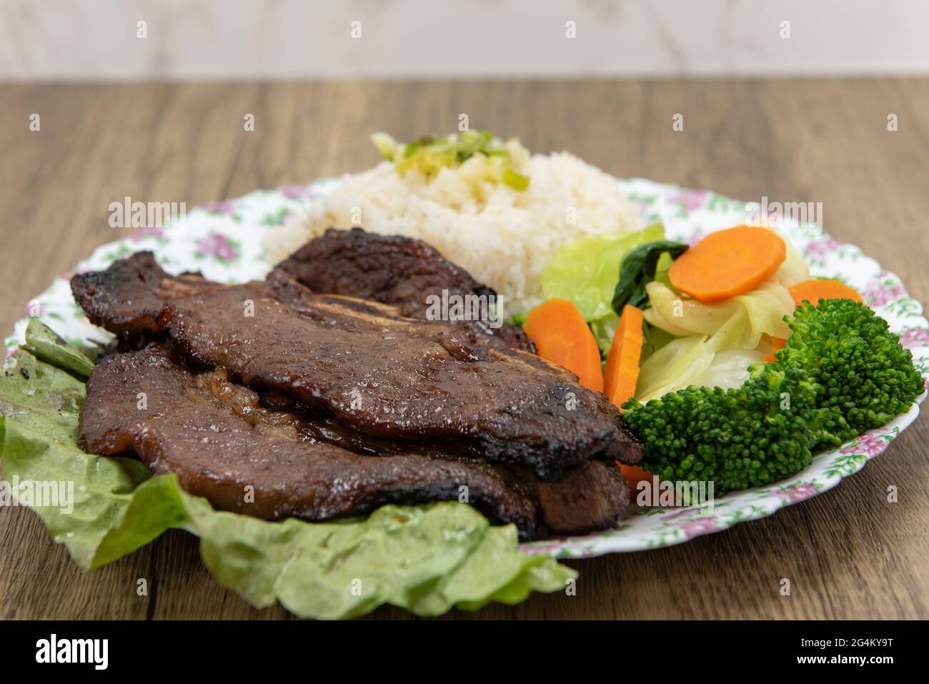 Hearty plate loaded with BBQ short ribs, rice and vegetables for a ...