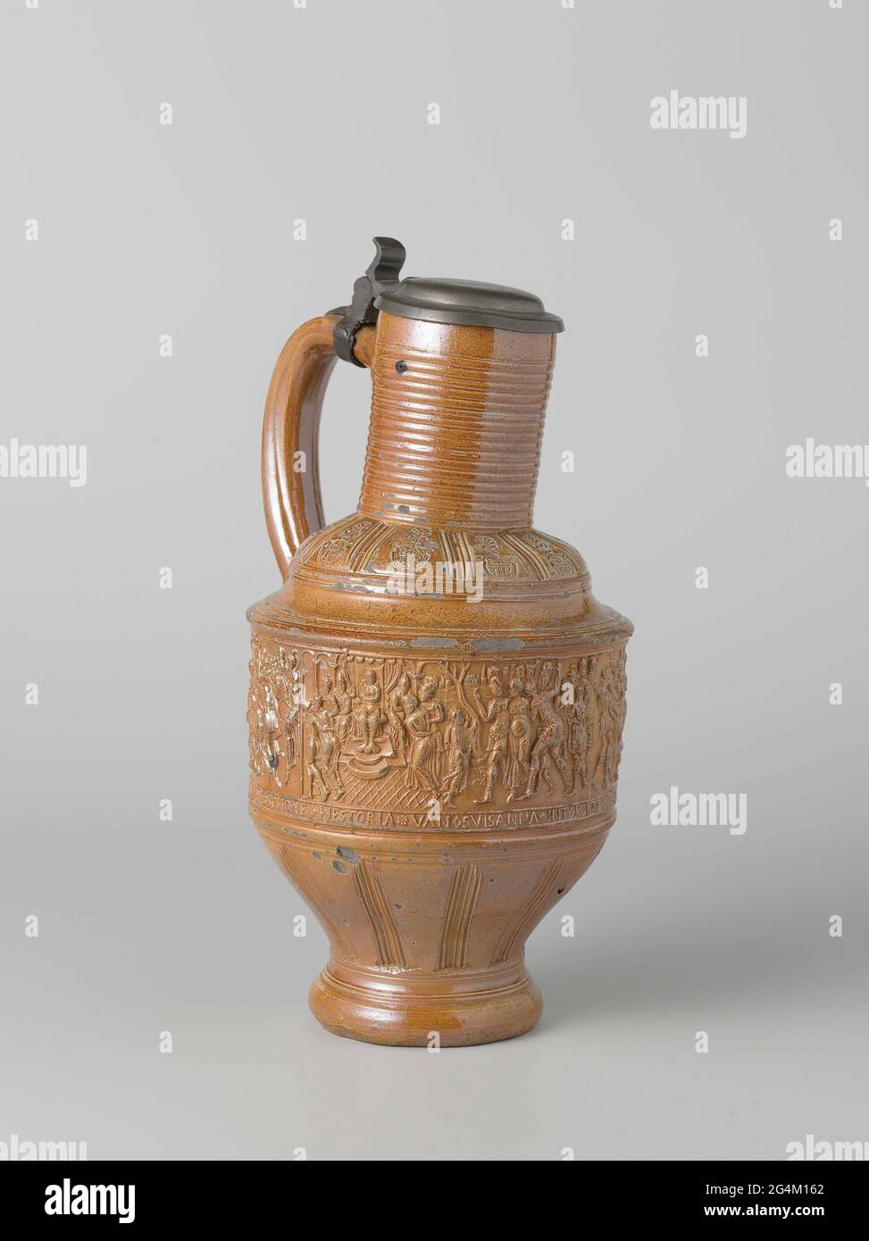 . Brown jug of pottery with pewter lid. Belly with a straight-handed ...