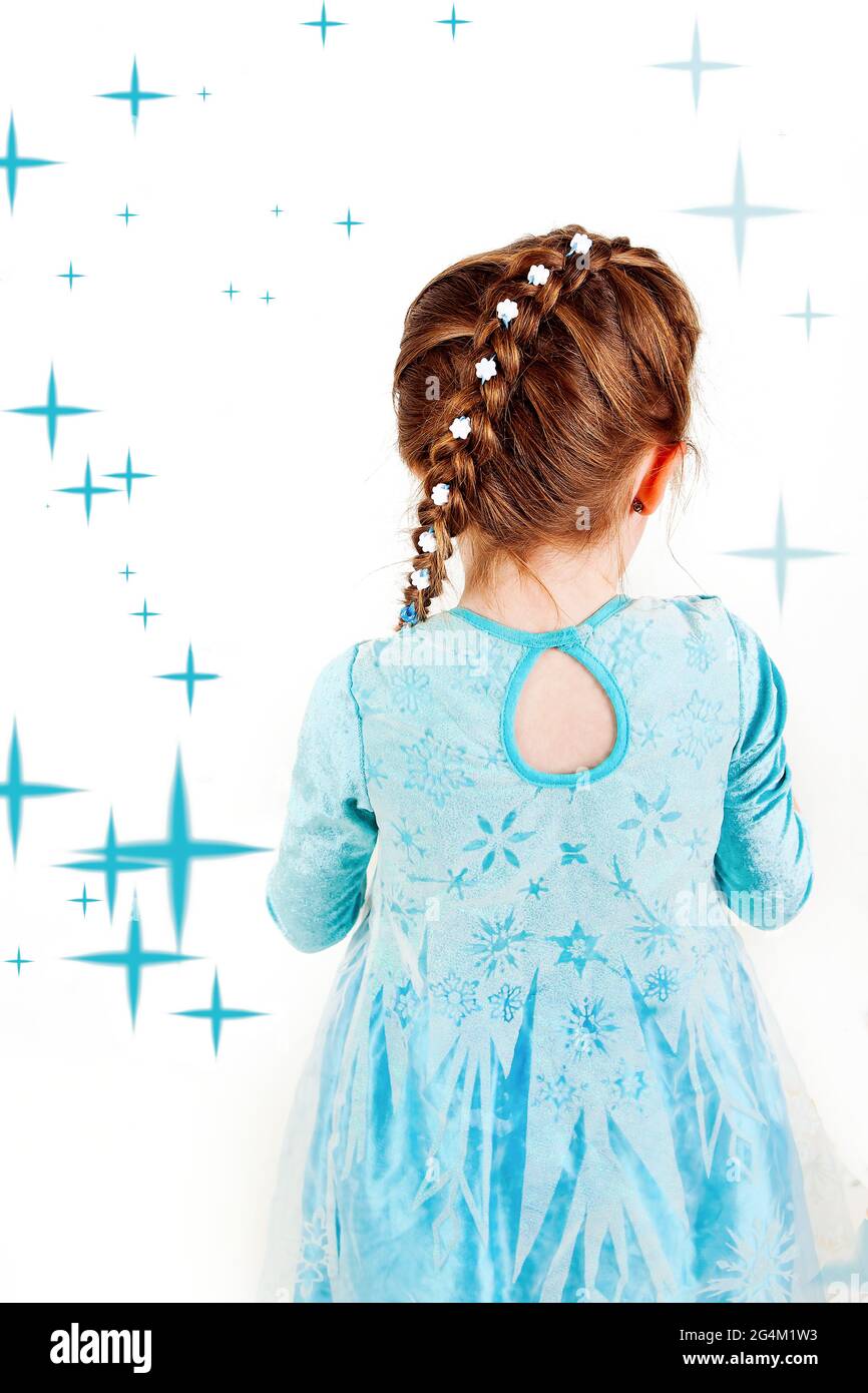 Girl dressed up in fancy dress, at a studio shoot. The girl's hair is braided, with a star ...