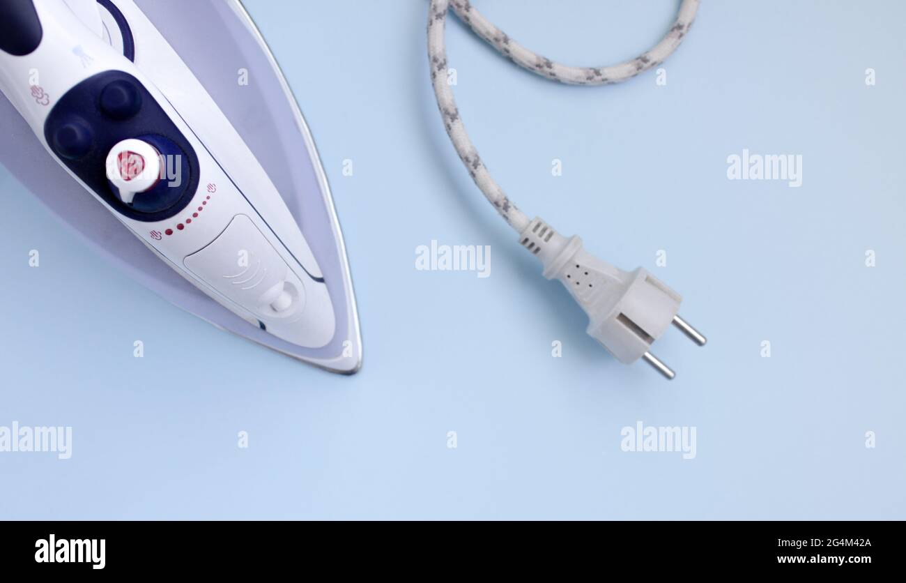 Iron for ironing things on a blue background. Top view, copy space ...