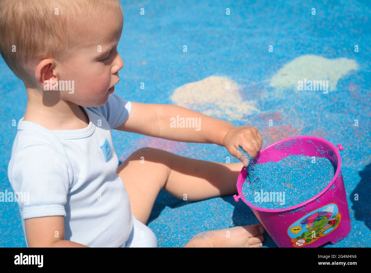 One year old baby boy play in sandpit with blue sand Stock Photo - Alamy