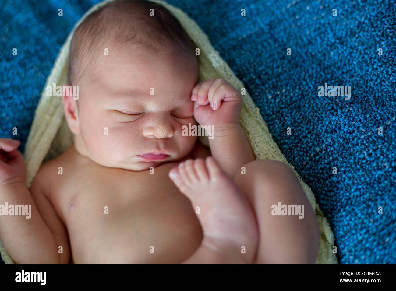Newborn baby boy, sleeping peacefully wrapped in knitted wrap Stock Photo - Alamy