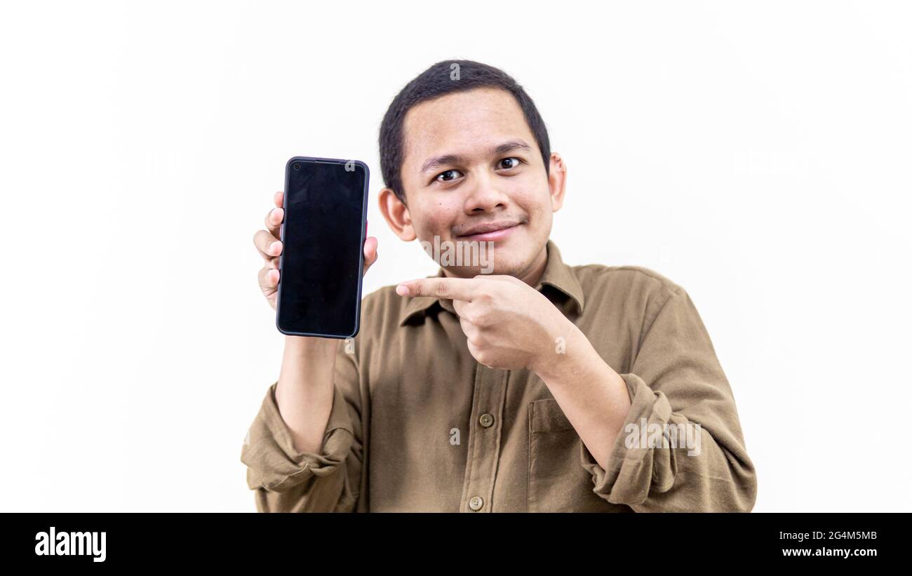 Young Malay pointing at the black screen of his smartphone and smi ...
