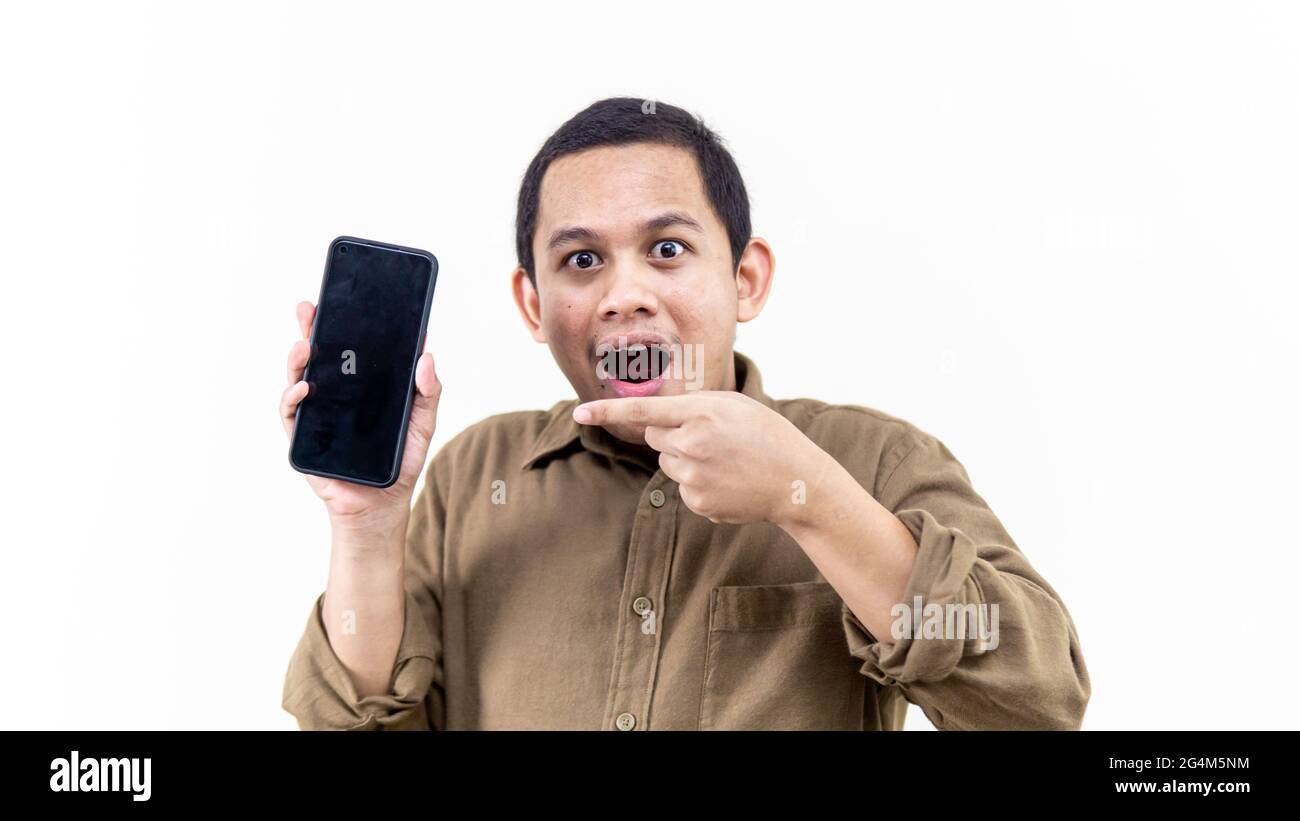 Young Malay pointing at the black screen of his smartphone with a ...