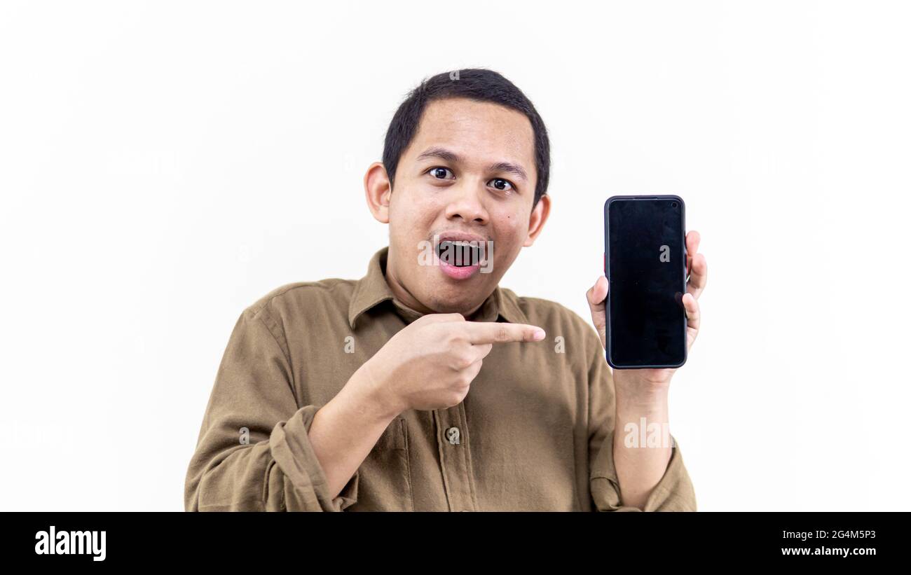 Young Malay pointing at the black screen of his smartphone with a ...