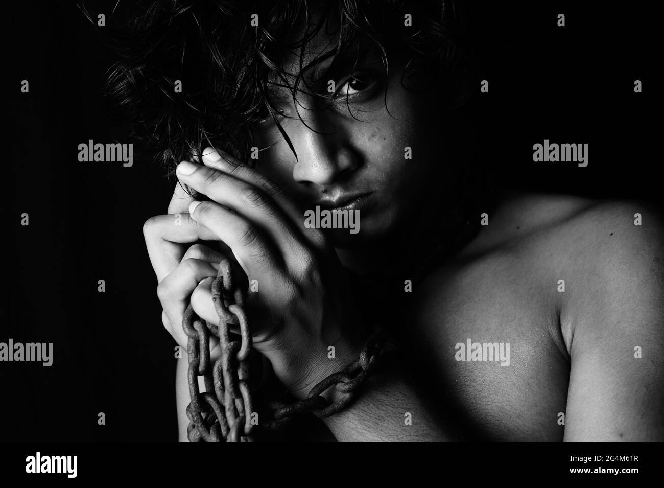 Grayscale shot of a chained up guy Stock Photo - Alamy