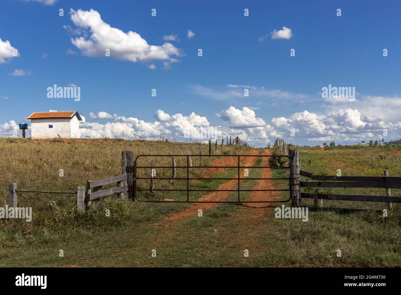Fenced farmland with a farmhouse in the background Stock Photo - Alamy