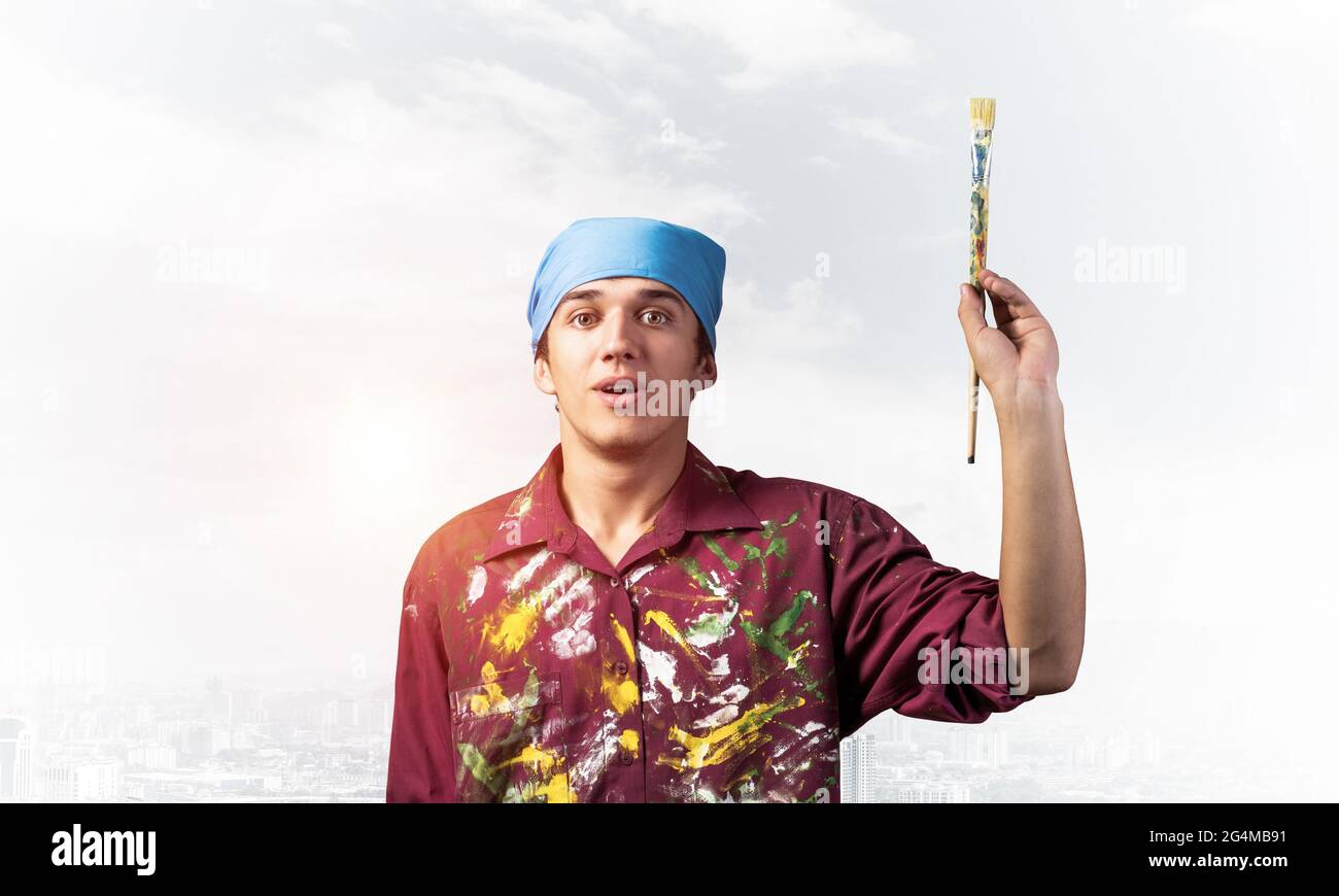 Handsome young painter artist pointing upwards Stock Photo - Alamy