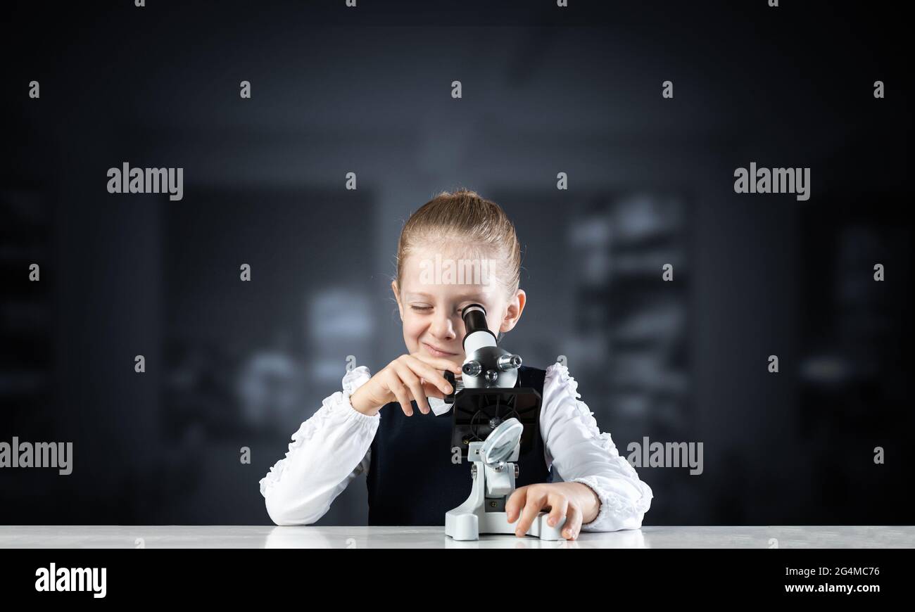Little scientist looking through microscope Stock Photo - Alamy