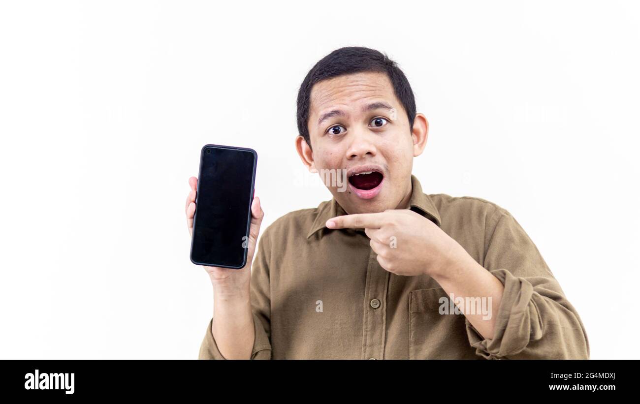 Young Malay pointing at the black screen of his smartphone with a ...