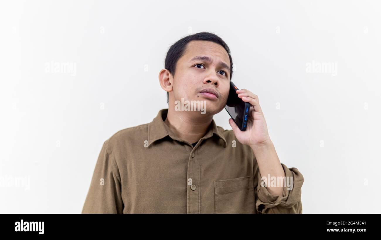 Young Malay man having a serious conversation on the smartphone on ...