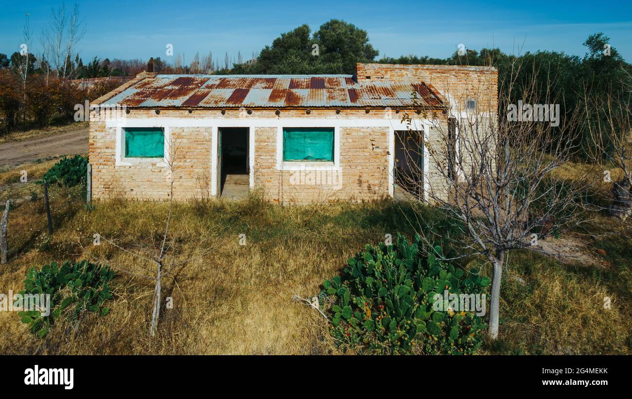 Old abandoned brick house with a rusty roof in the field Stock Photo ...