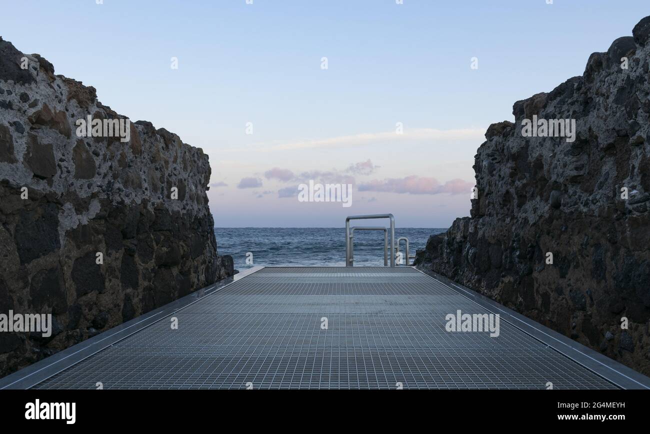 Pathway surrounded by stone walls leading towards the ocean Stock Photo ...