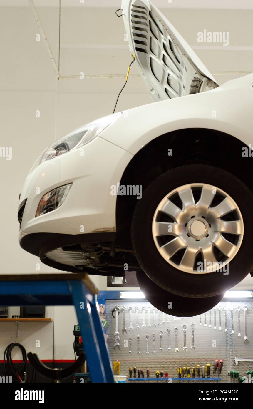 Vertical shot of a car on a hydraulic ramp lift at a service center ...