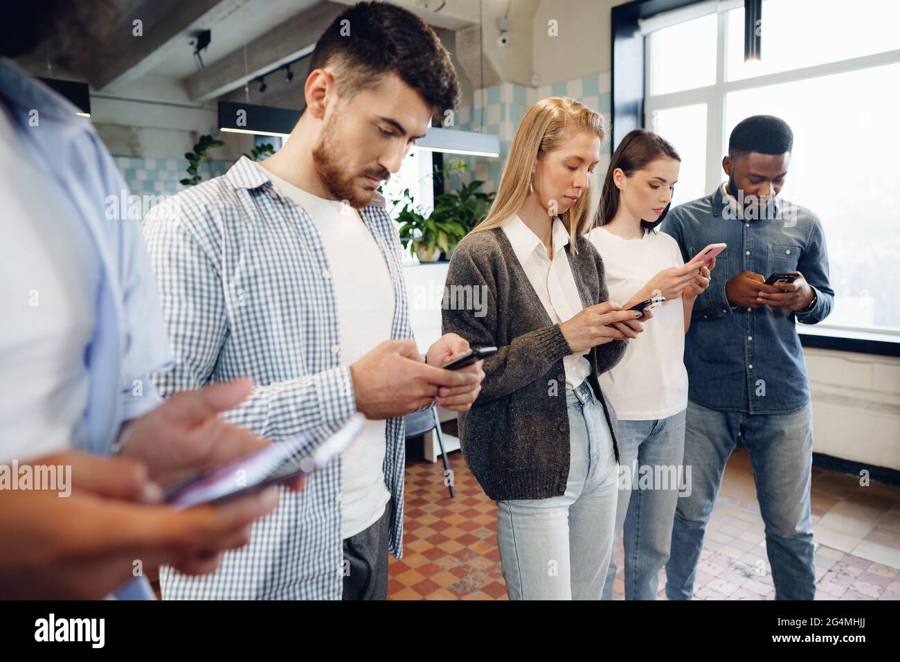 Diverse young people colleagues working on mobile phones together in ...