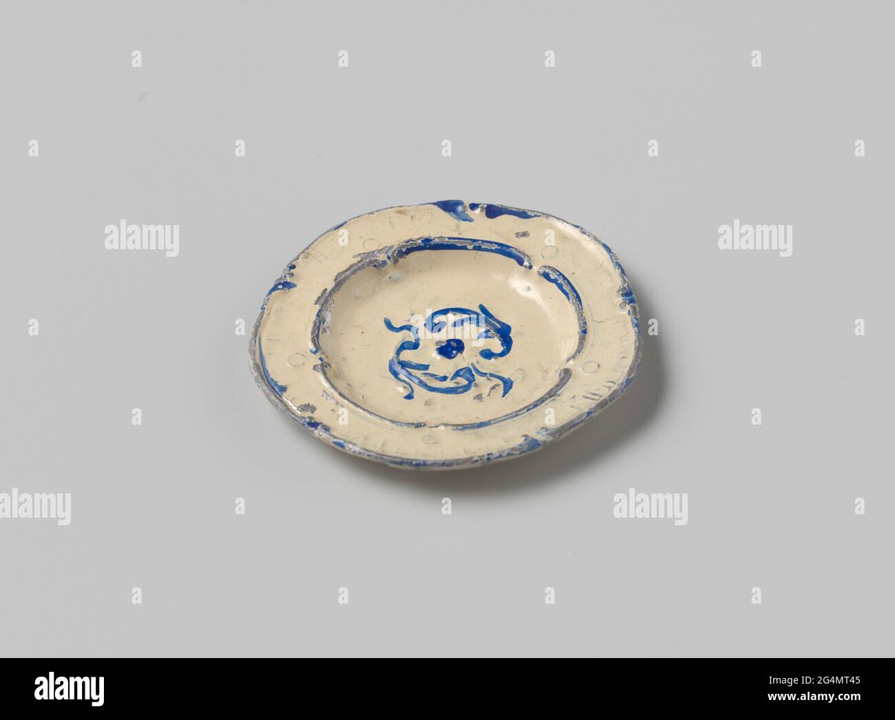 Miniature plate. Miniature plate decorated with blue curly motifs Stock ...