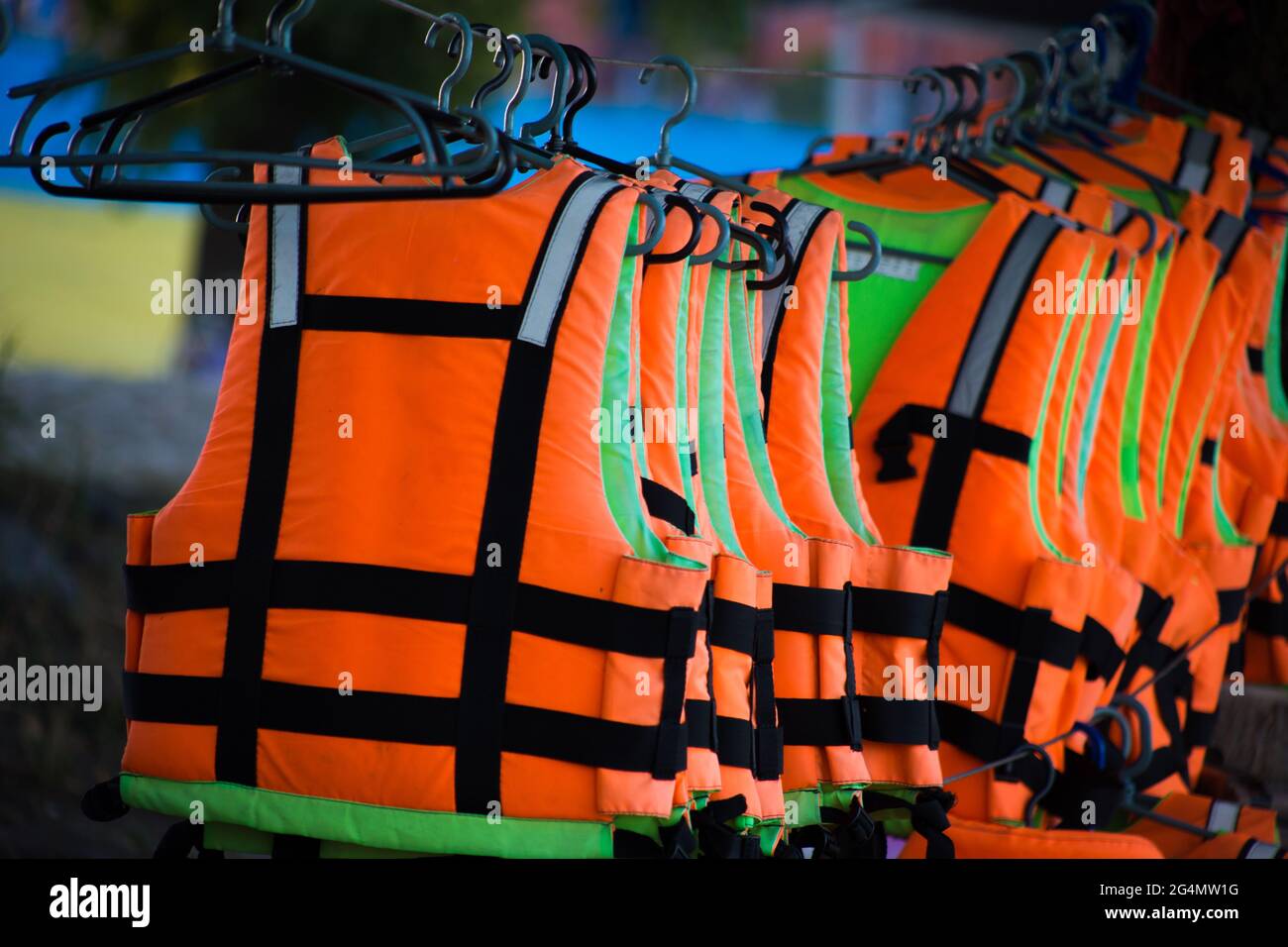 A stack of orange life jackets hanging on a hanger Stock Photo - Alamy