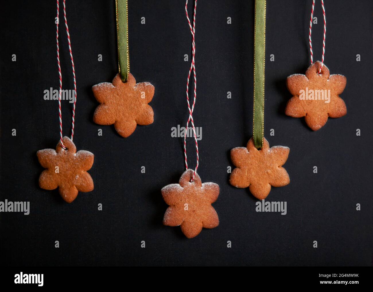 Homemade gingerbread snowflakes on ribbons on black background Stock ...