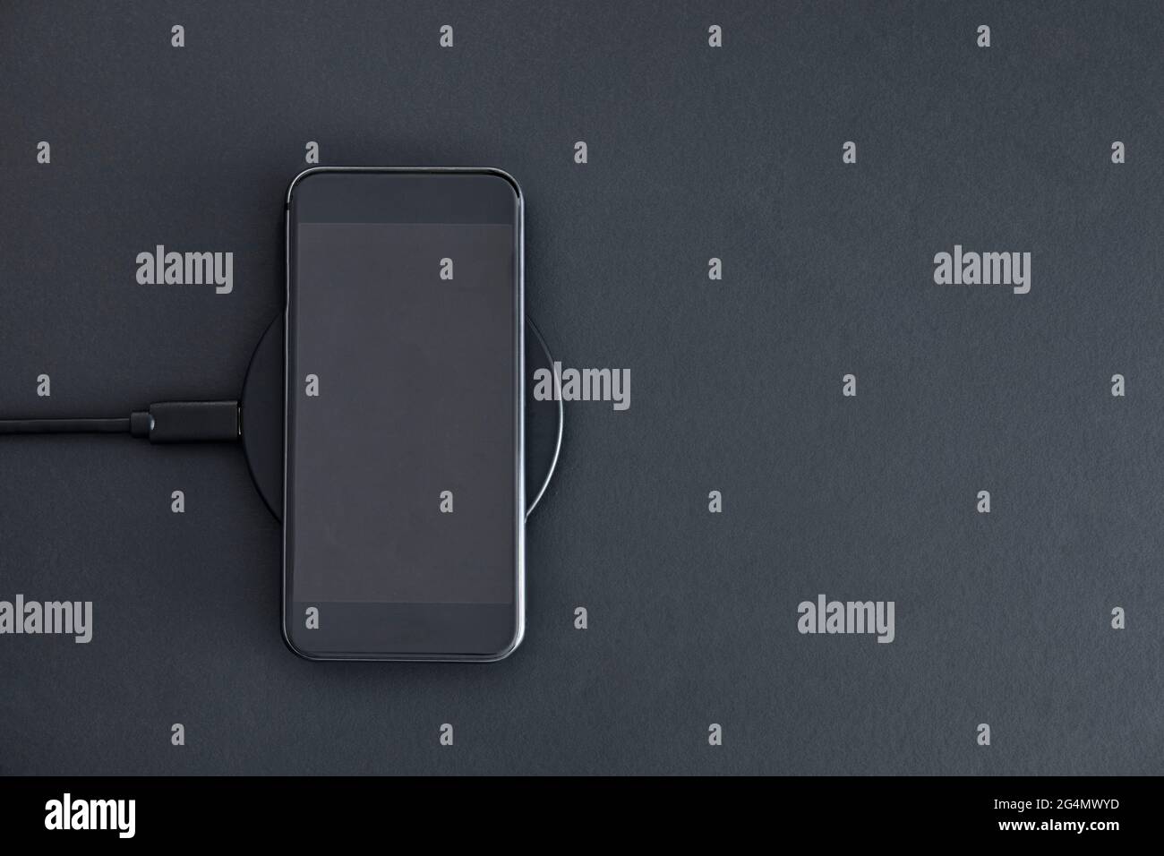 Induction wireless charging of mobile phone. High angle view of ...