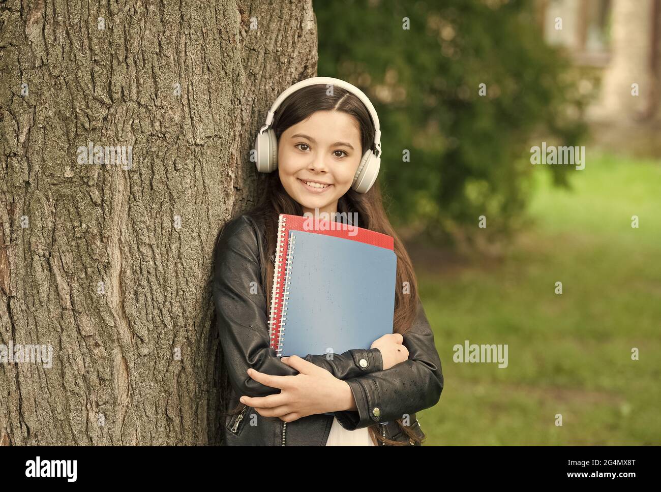 Girl listening audio carry textbooks relaxing park background, sound in ...