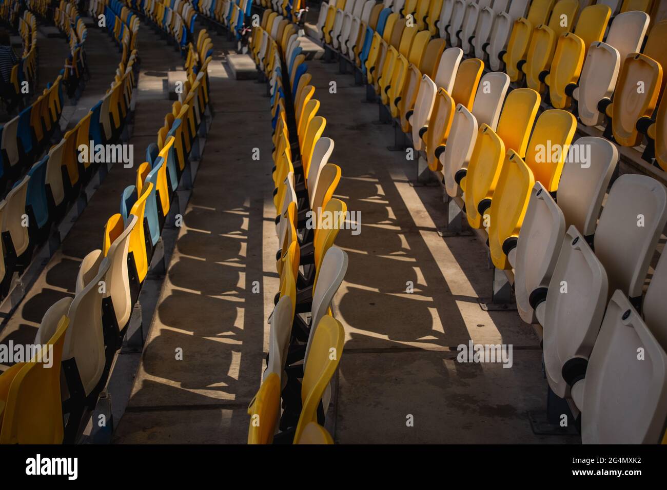 Empty rows of seats in a football stadium with yellow and blue benches ...