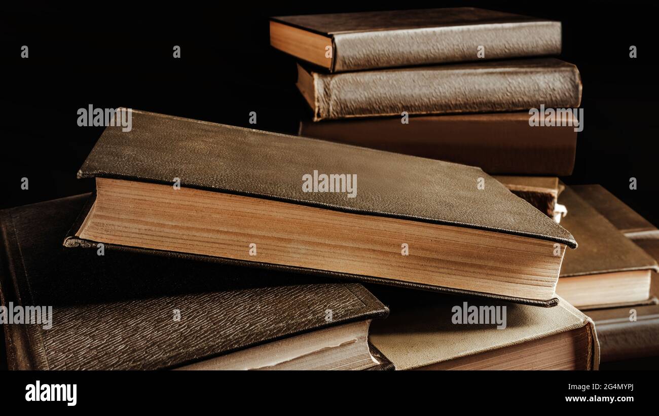 Photo of old fashioned stack of books on dark background Stock Photo ...