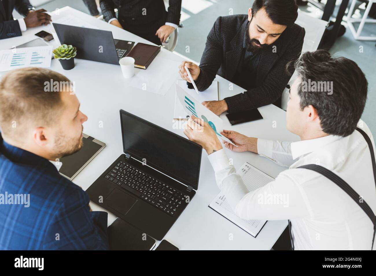 Young business people working and communicating while sitting at the ...