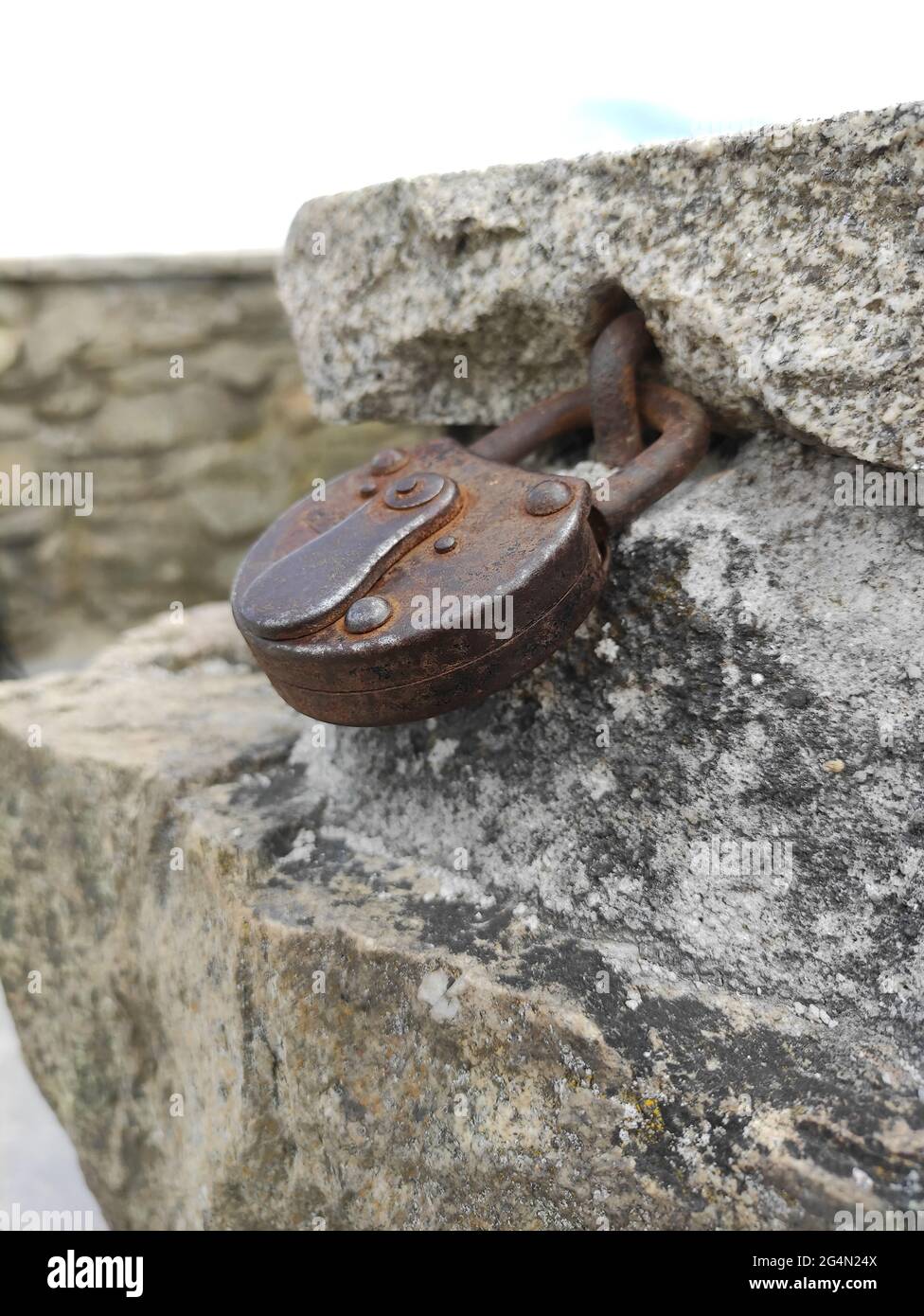 Closeup shot of a rusted old lock on a hook in a rock Stock Photo - Alamy